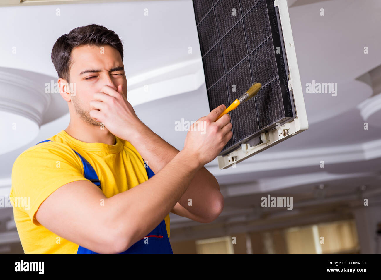 Repairman repairing ceiling air conditioning unit Stock Photo - Alamy