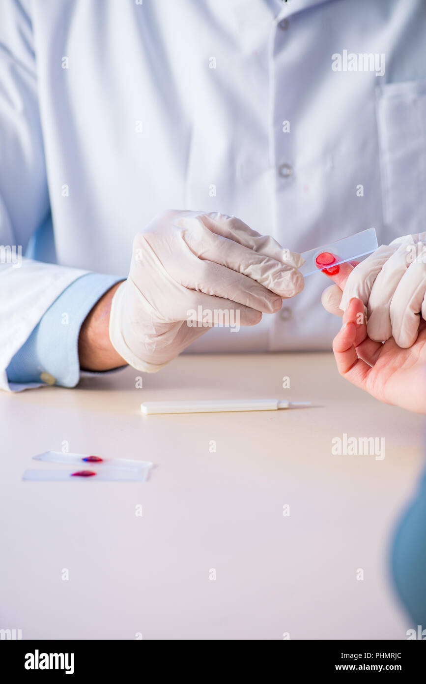 Doctor taking blood samples from finger Stock Photo - Alamy