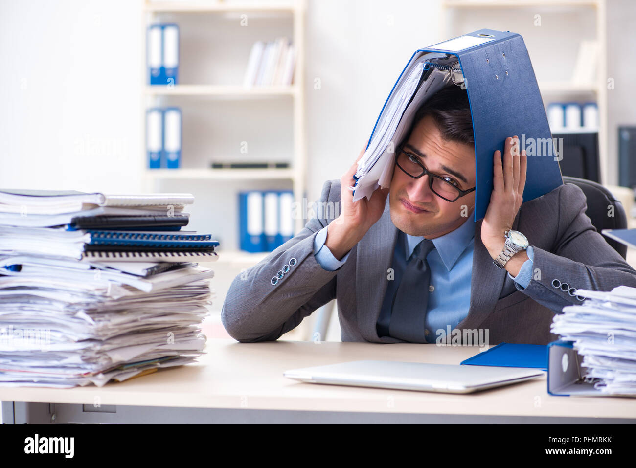 Overloaded with work employee under paperwork burden Stock Photo - Alamy