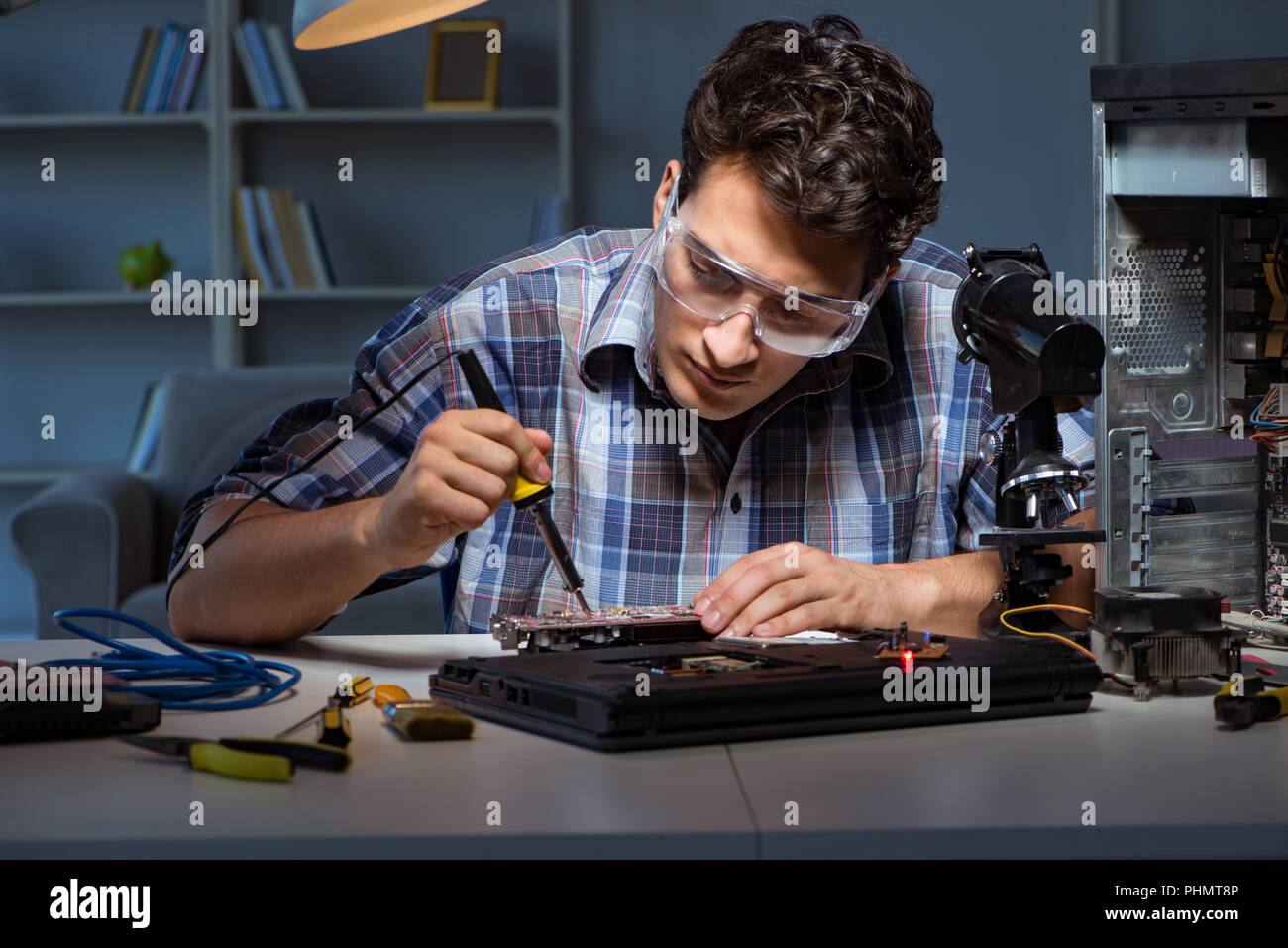 Young repair technician soldering electrical parts on motherboar Stock ...