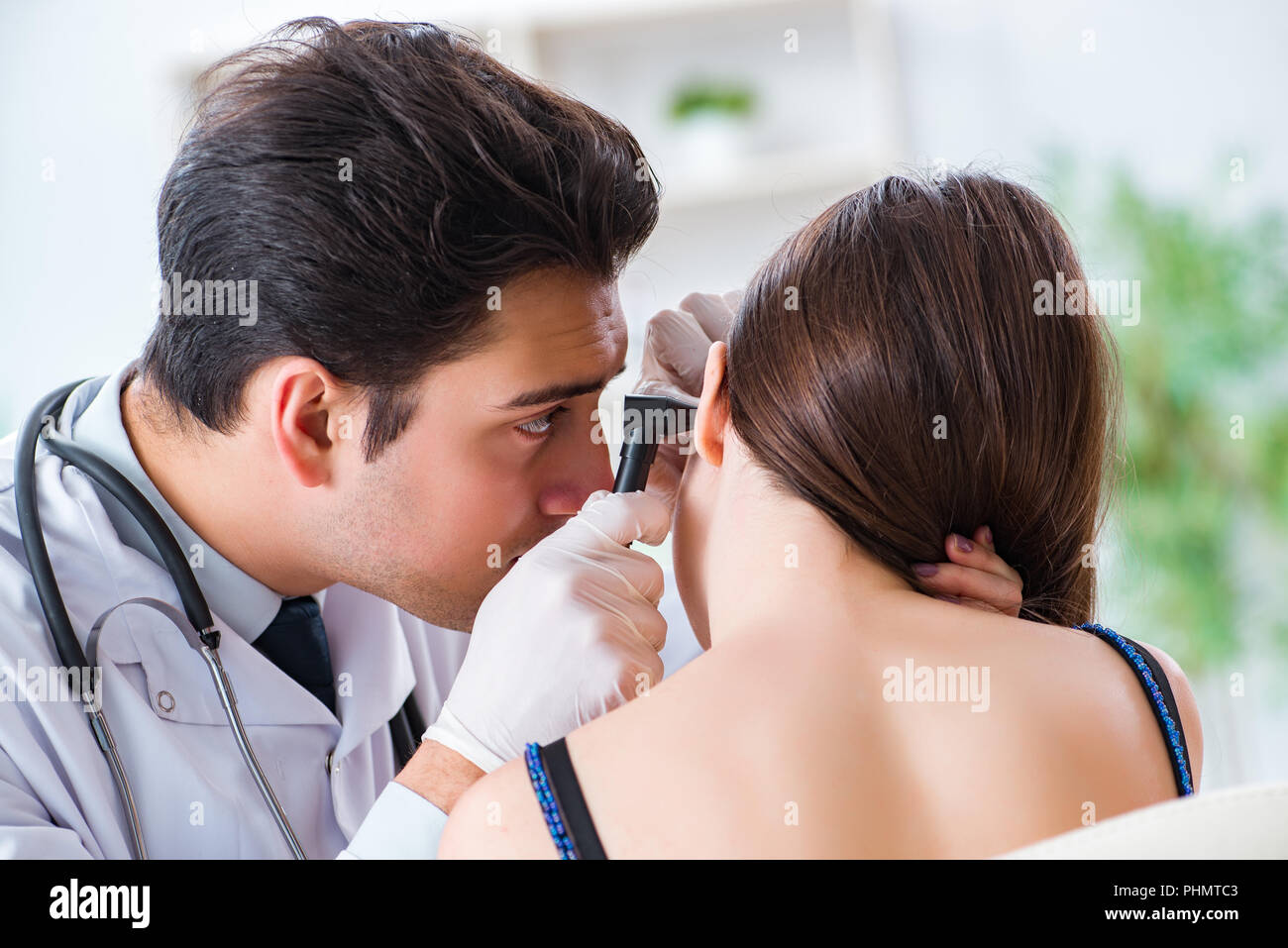 Doctor checking patients ear during medical examination Stock Photo - Alamy
