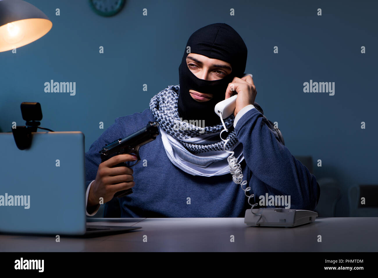 Terrorist burglar with gun working at computer Stock Photo - Alamy