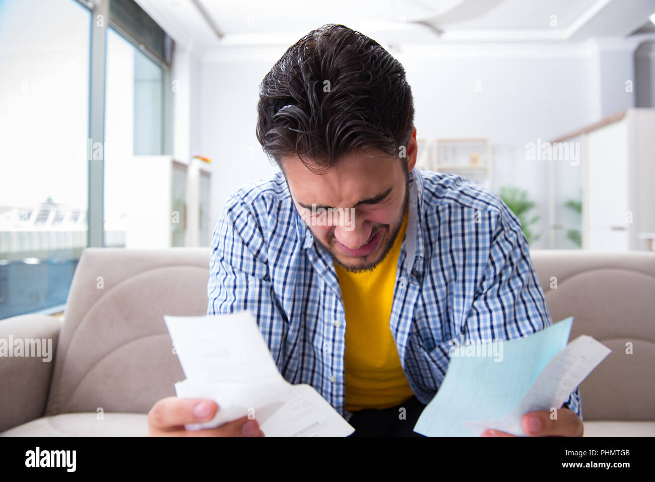 Man angry at bills he needs to pay Stock Photo - Alamy