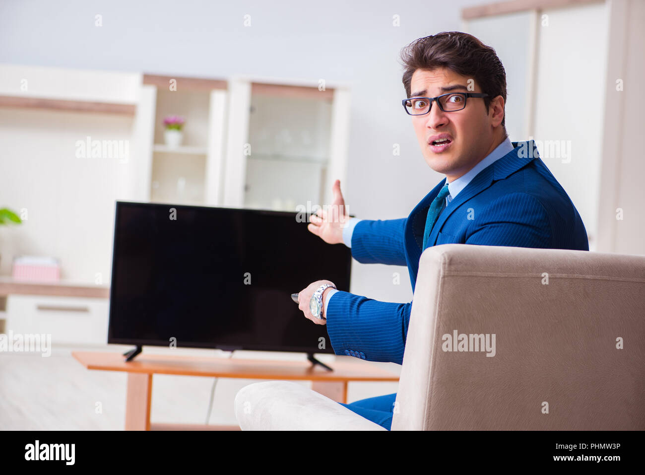 Businesman watching tv in office Stock Photo - Alamy