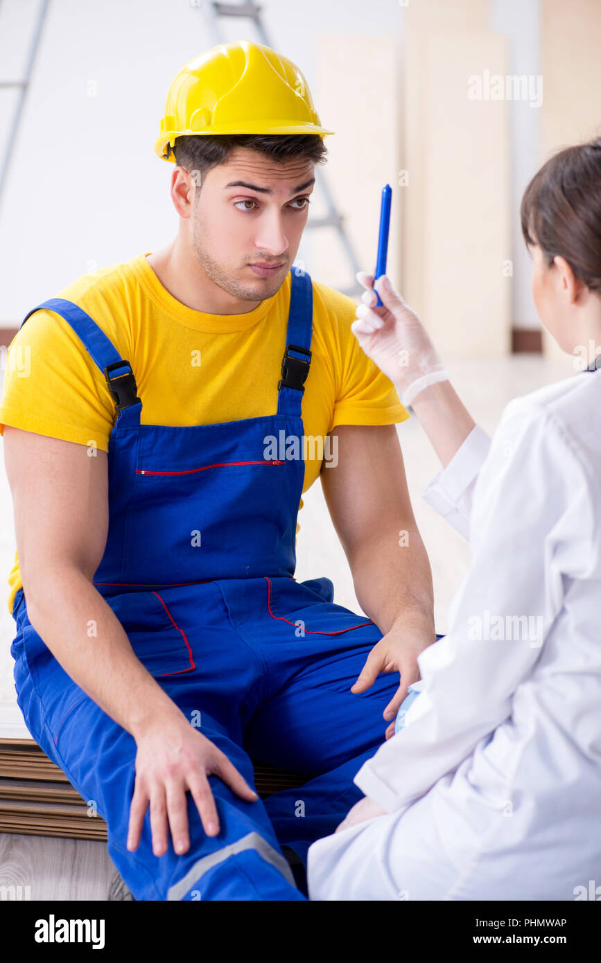 Doctor helping injured worker at construction site Stock Photo - Alamy