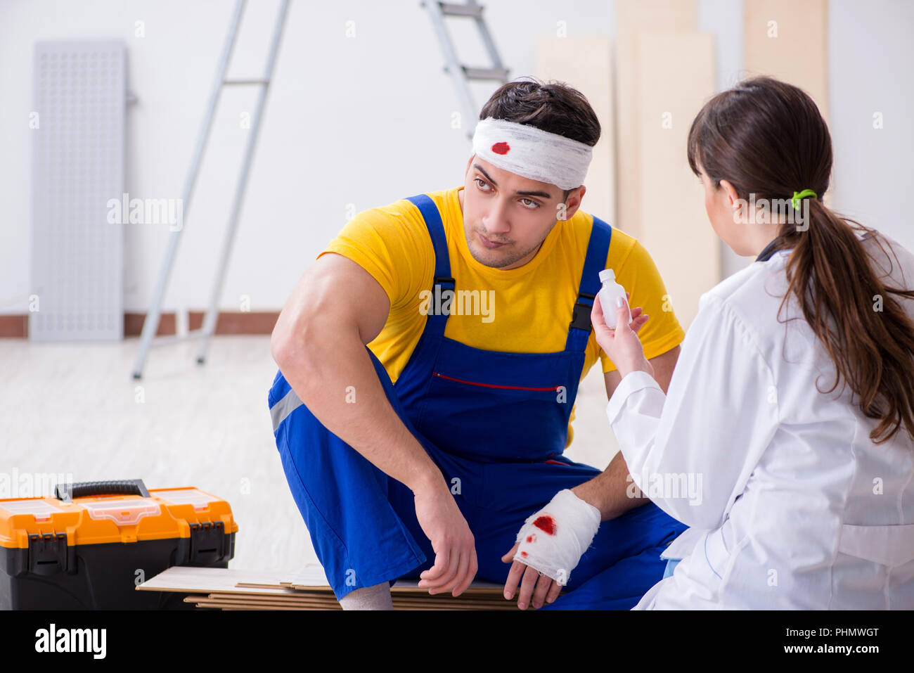 Worker with injured head and doctor Stock Photo - Alamy