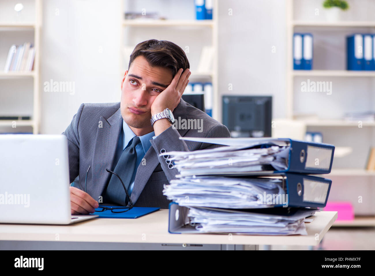 Overloaded with work employee under paperwork burden Stock Photo - Alamy