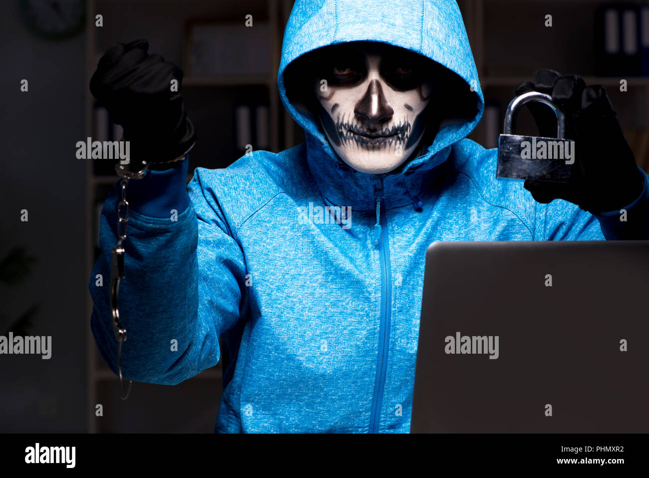 Scary hacker hacking security firewall late in office Stock Photo - Alamy