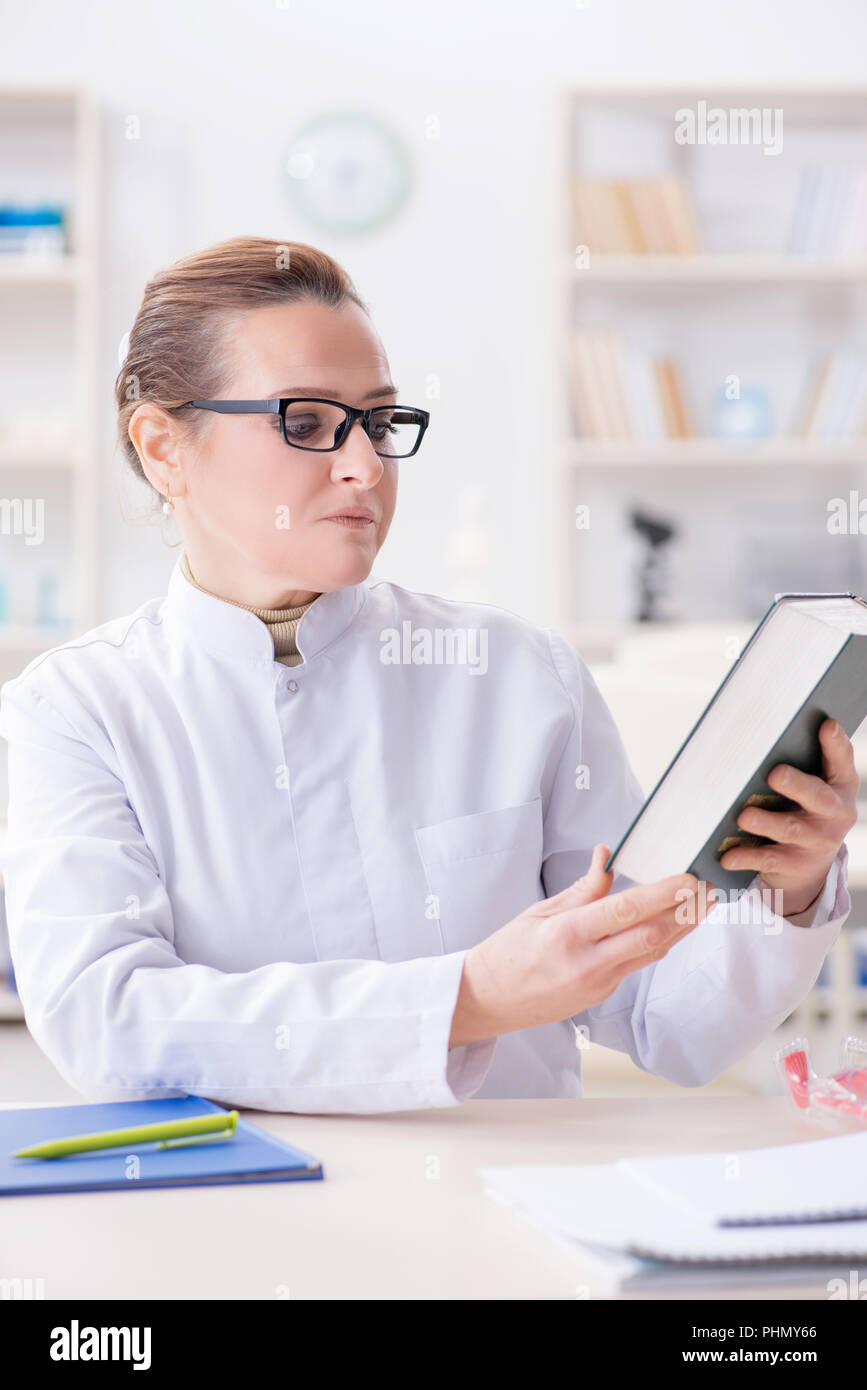 Woman doctor reading book Stock Photo - Alamy