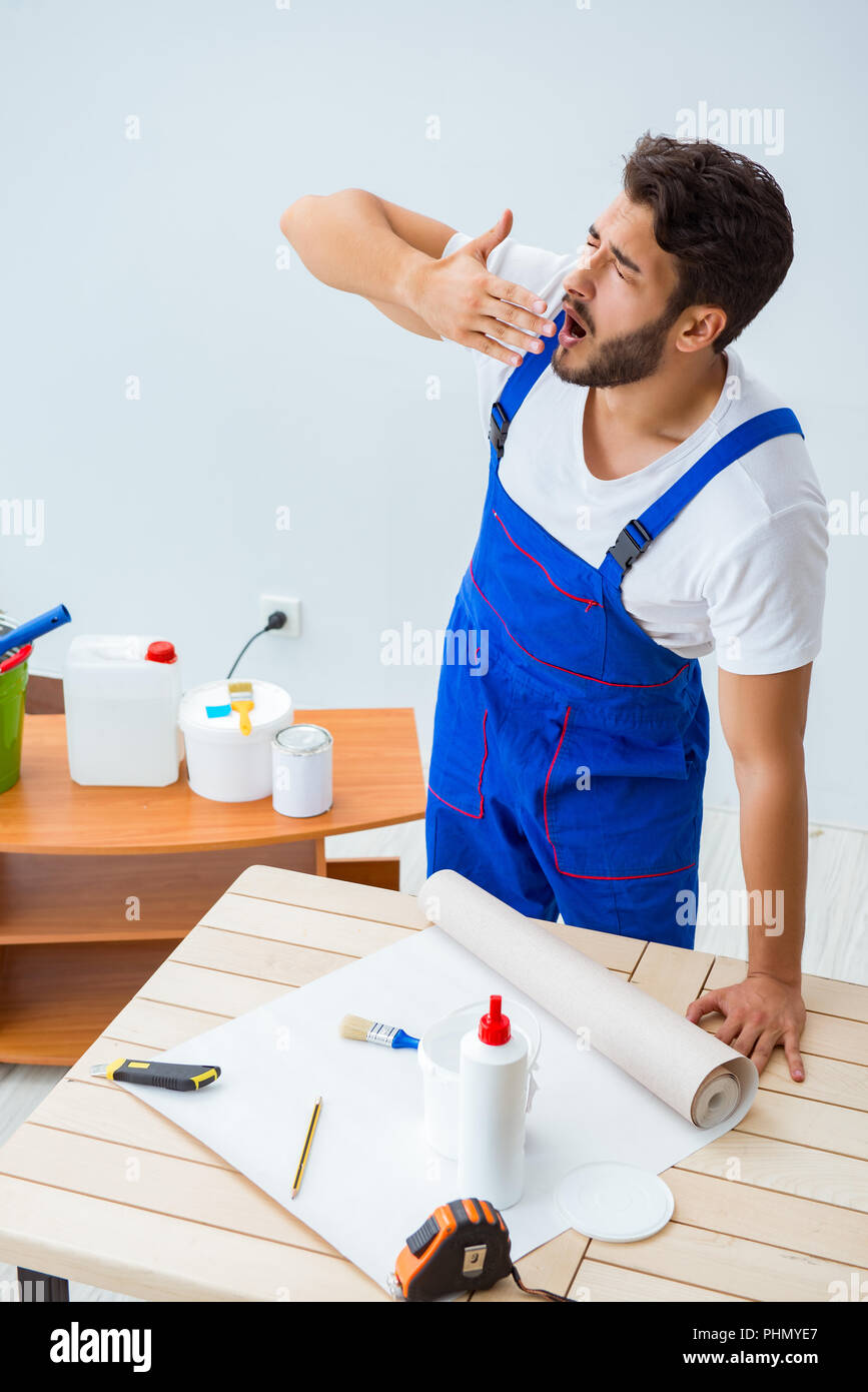Worker working on wallpaper during refurbishment Stock Photo - Alamy
