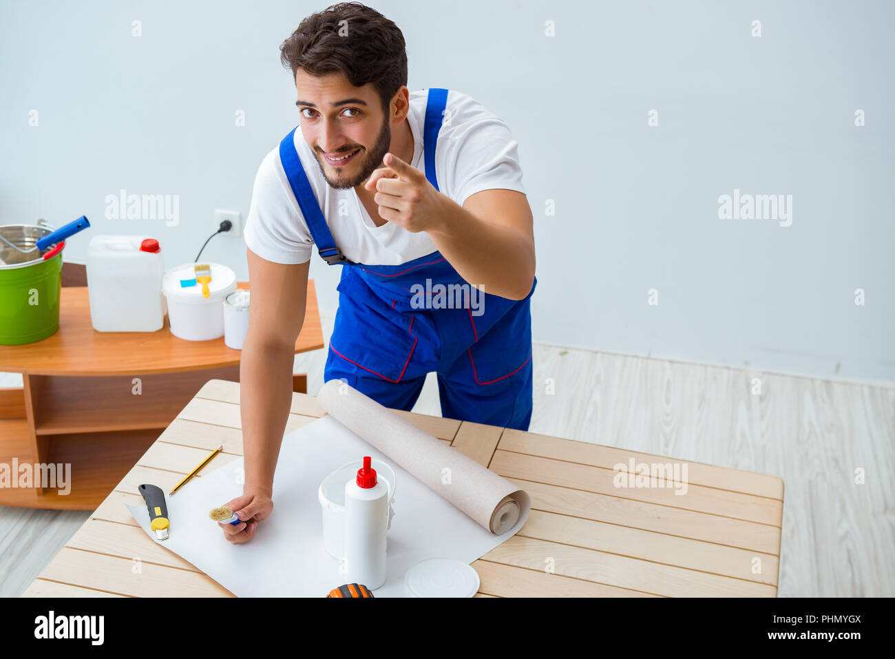 Worker working on wallpaper during refurbishment Stock Photo - Alamy