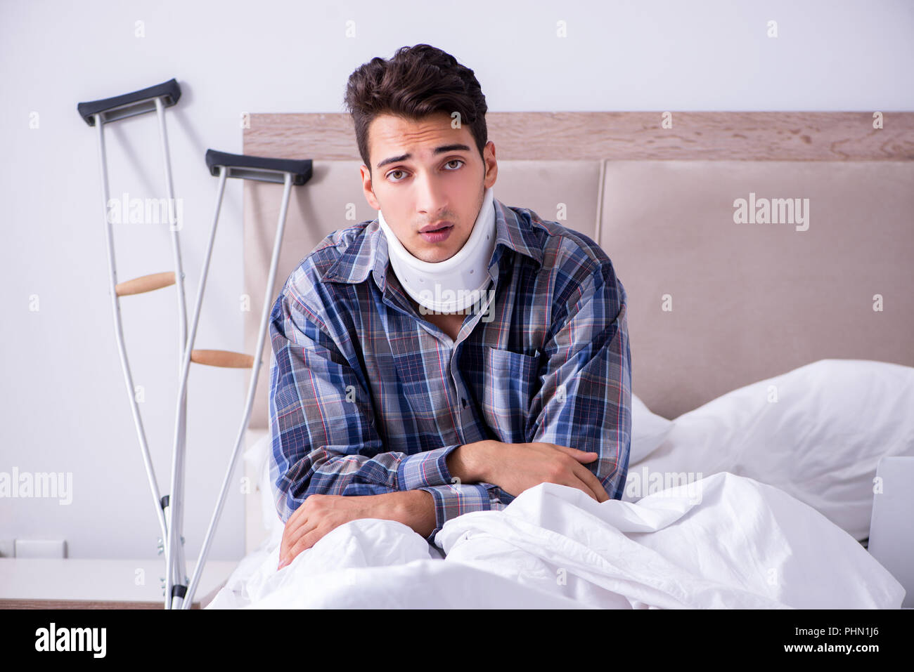 Injured man in bed at home with crutches Stock Photo - Alamy