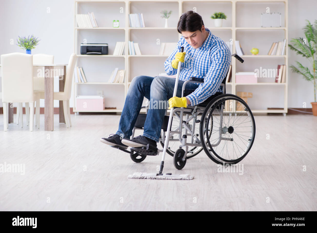 Disabled man on wheelchair cleaning home Stock Photo - Alamy