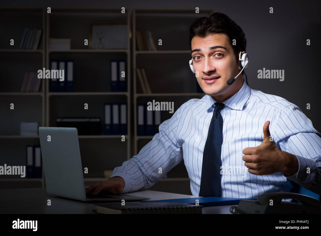 Call center operator talking to customer during night shift Stock Photo ...