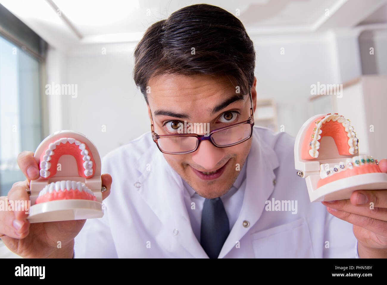 Funny dentist with teeth model in hospital Stock Photo - Alamy