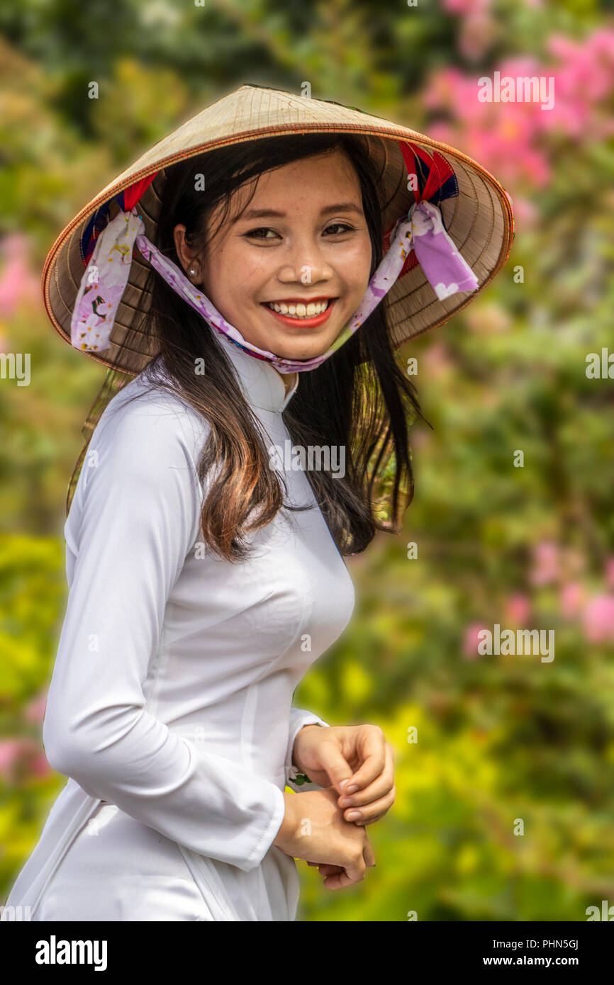 Gril in traditional Vietnamese dress Ao Dai and conical hat in Ho Chi Minh city Vietnam Stock ...