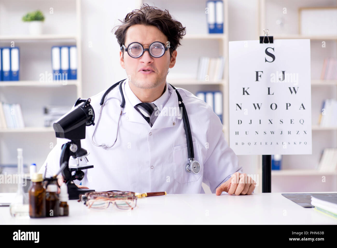 Funny eye doctor in humourous medical concept Stock Photo - Alamy