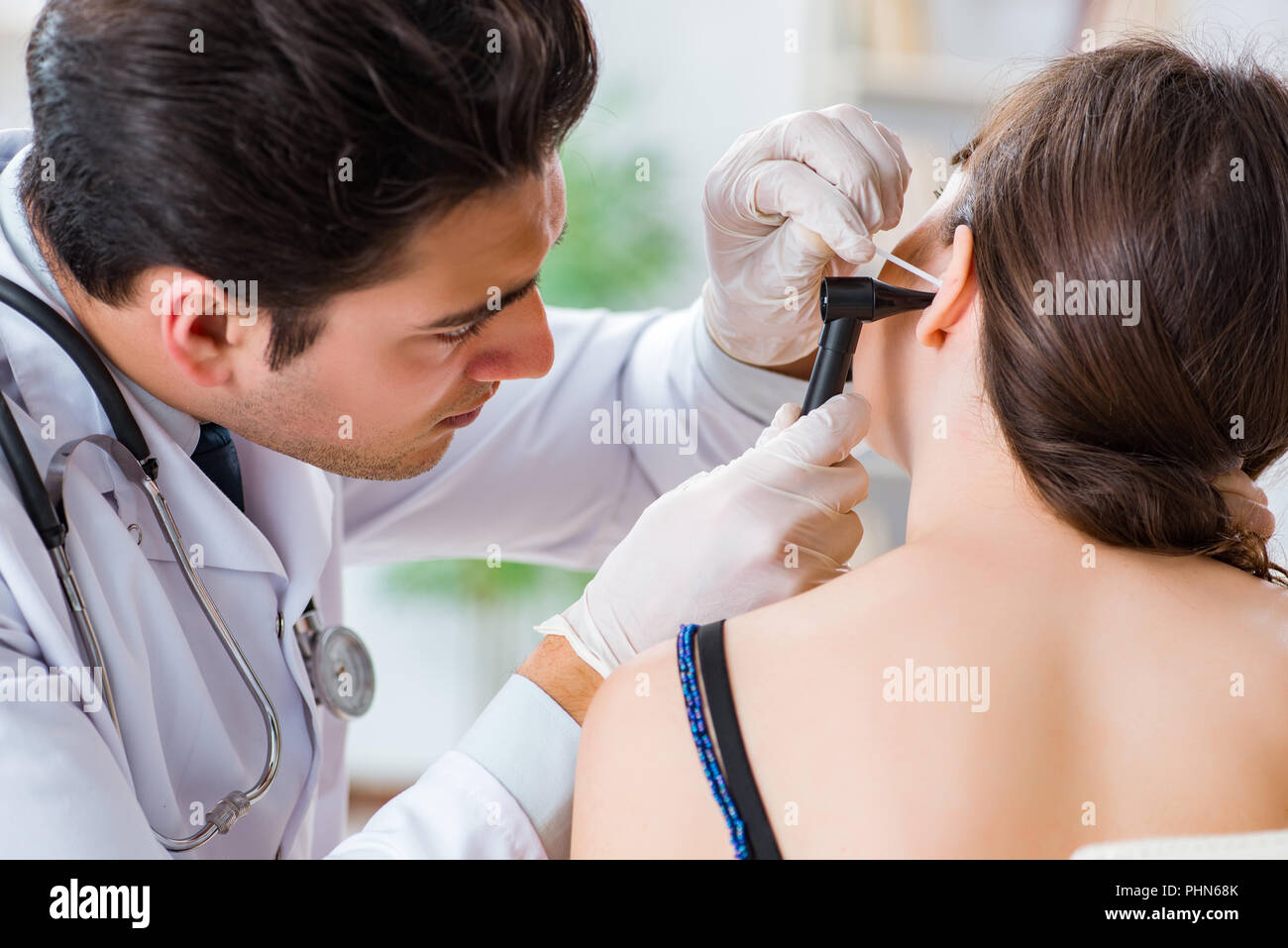Doctor checking patients ear during medical examination Stock Photo - Alamy