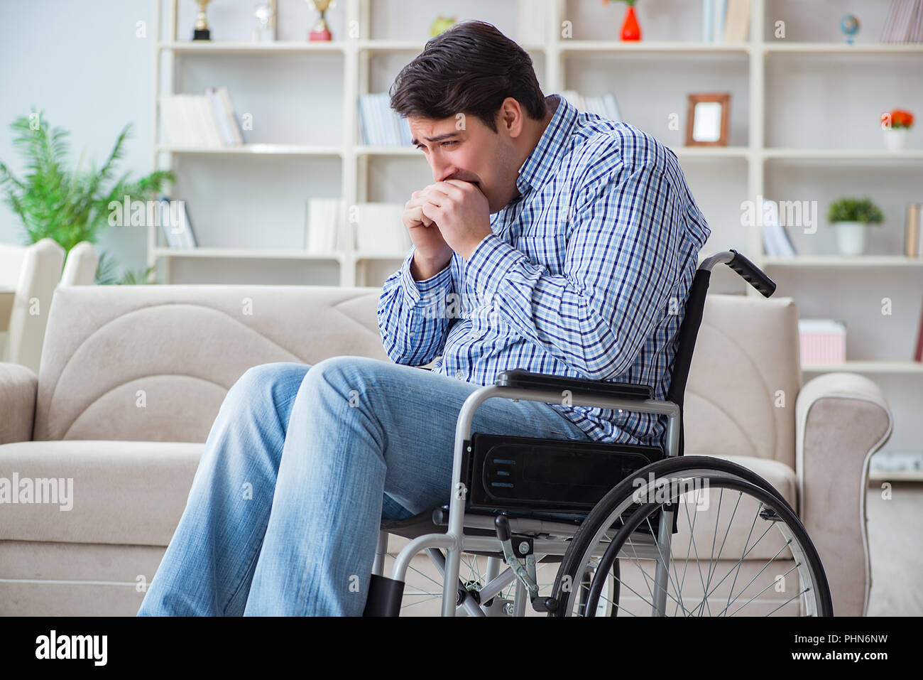 Disabled young man suffering at home Stock Photo - Alamy