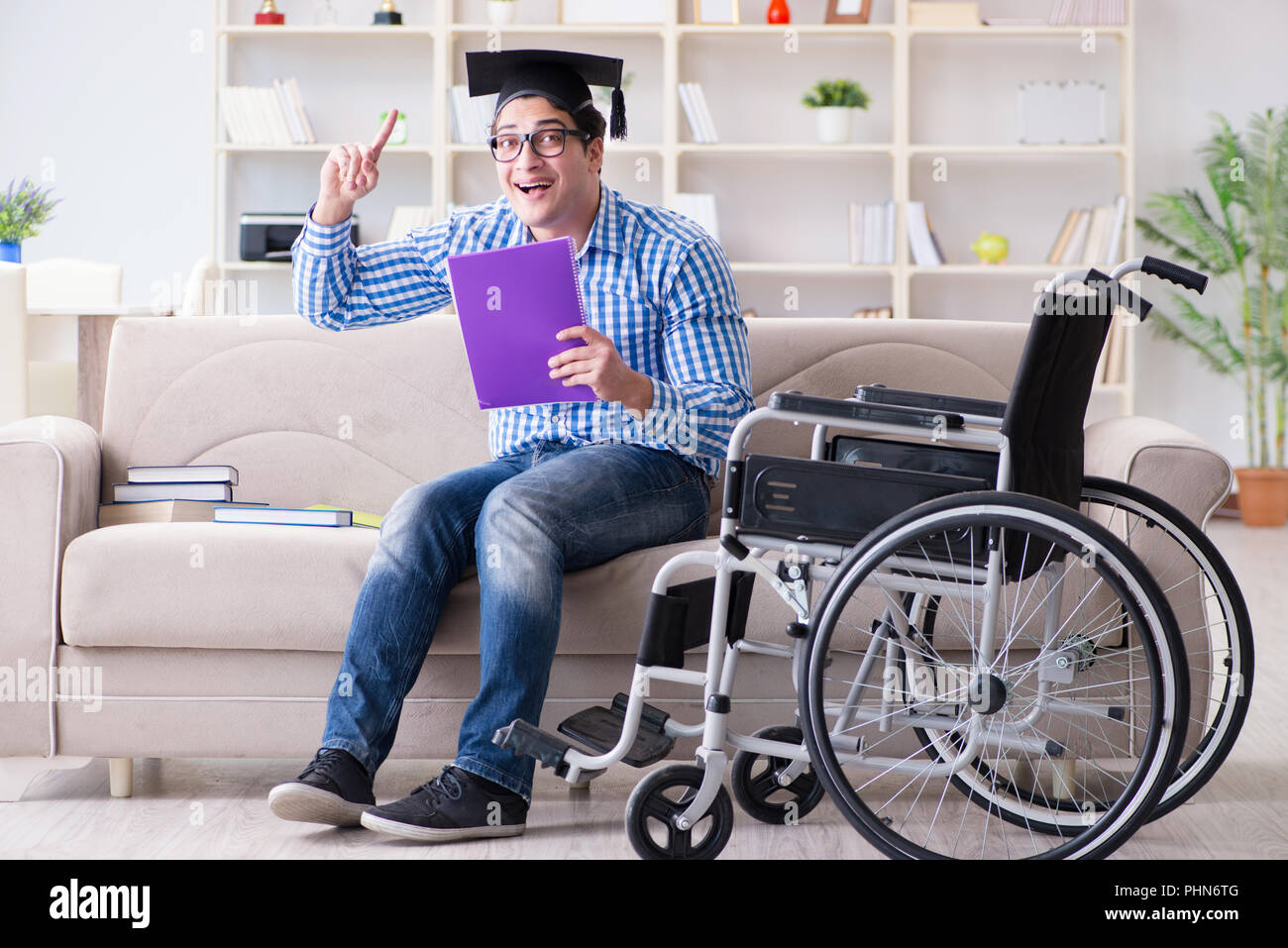 Young student on wheelchair in disability concept Stock Photo - Alamy