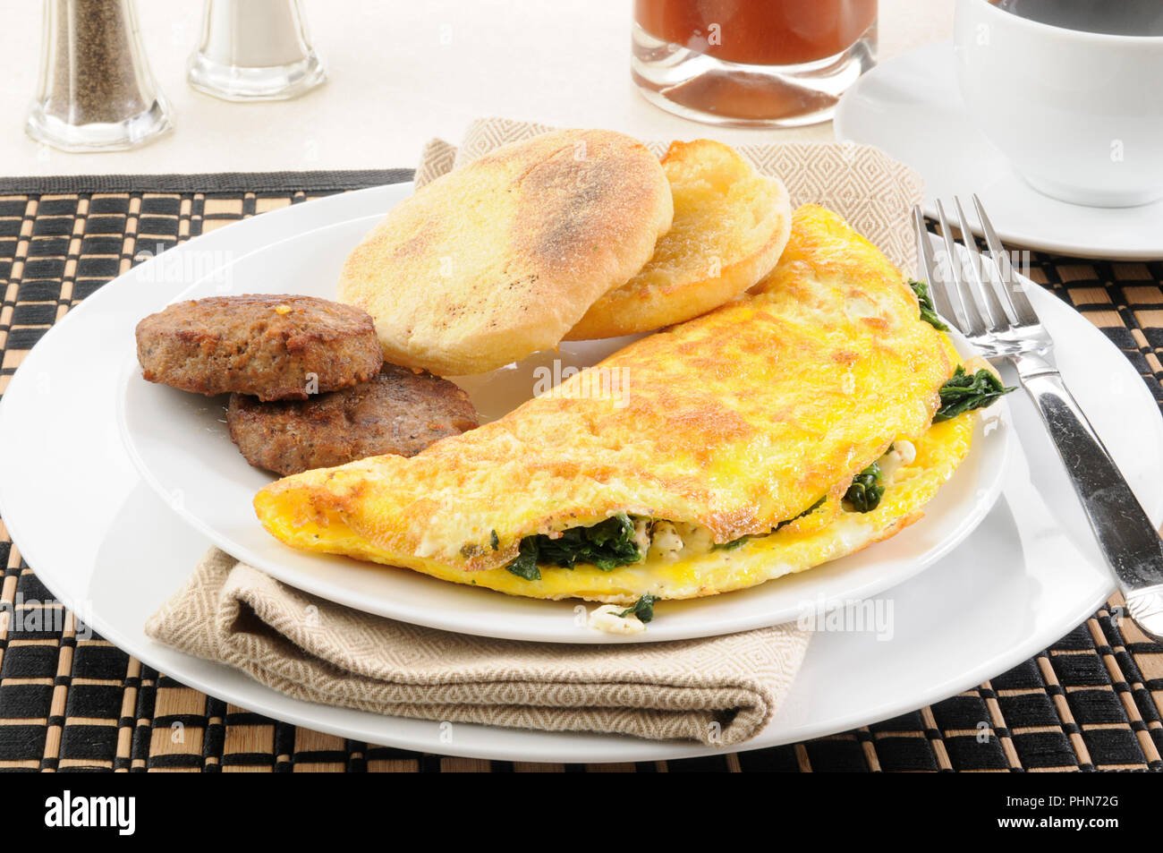 A spinach and feta cheese omelet with sausage and an english muffin ...