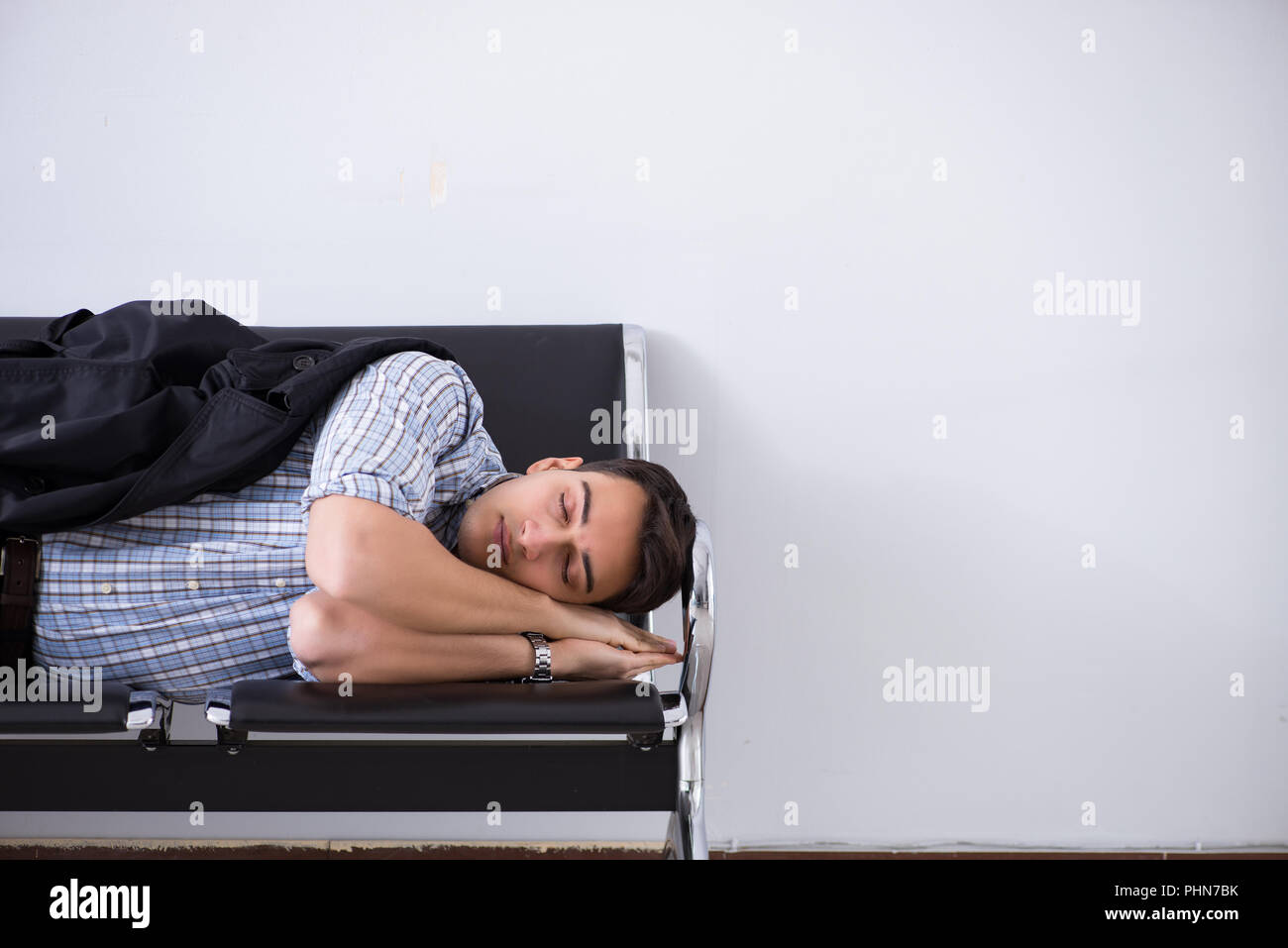 Man sleeping on the chairs in airport Stock Photo - Alamy