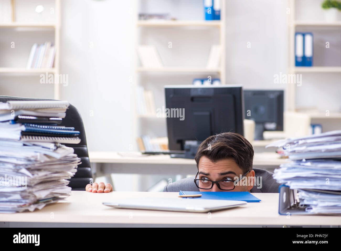 Overloaded with work employee under paperwork burden Stock Photo - Alamy