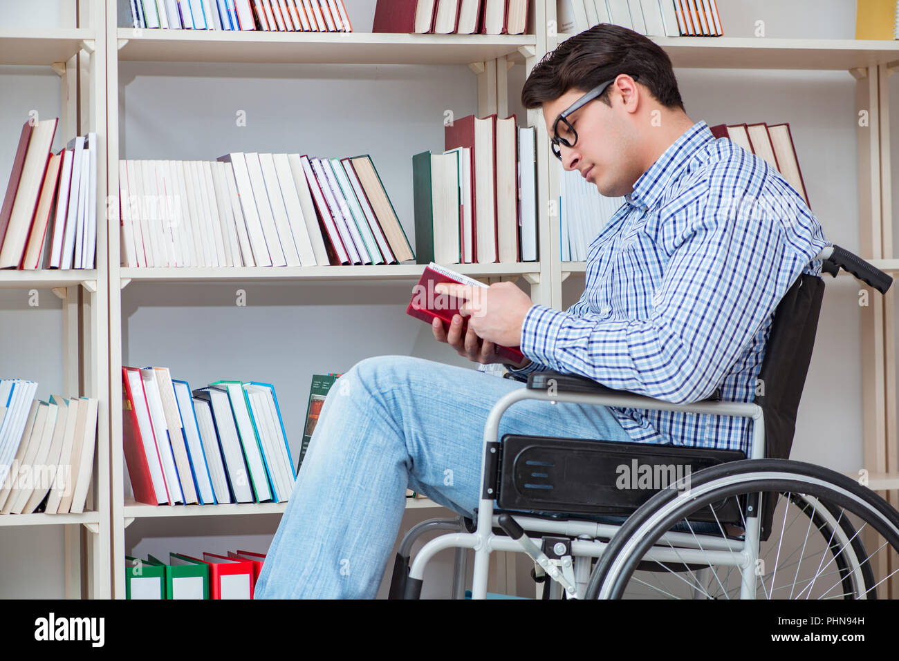 Disabled student studying in the library Stock Photo - Alamy