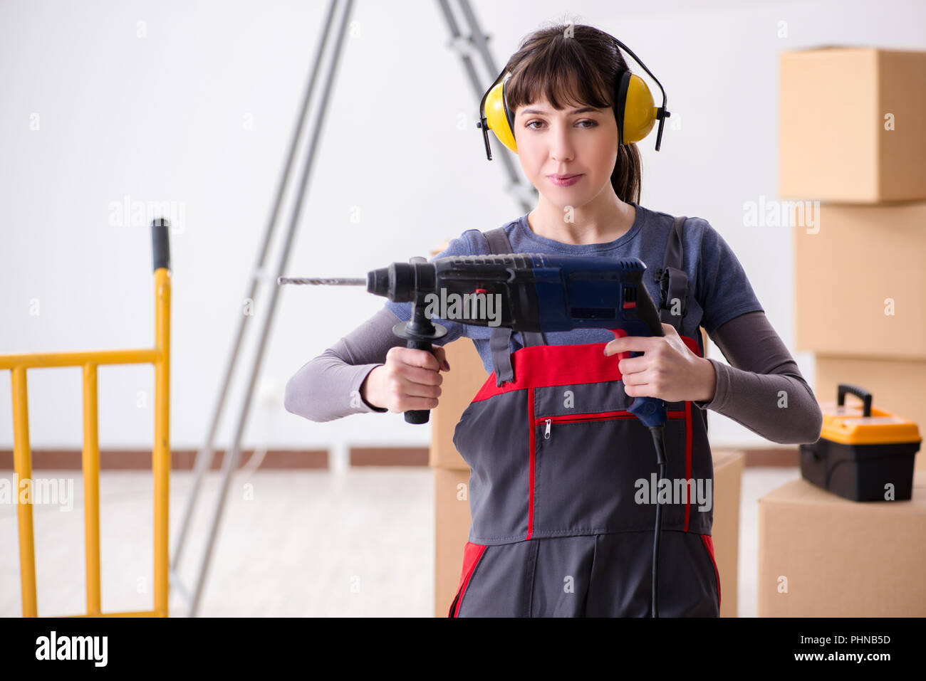 Woman contractor with hand drill at construction site Stock Photo - Alamy
