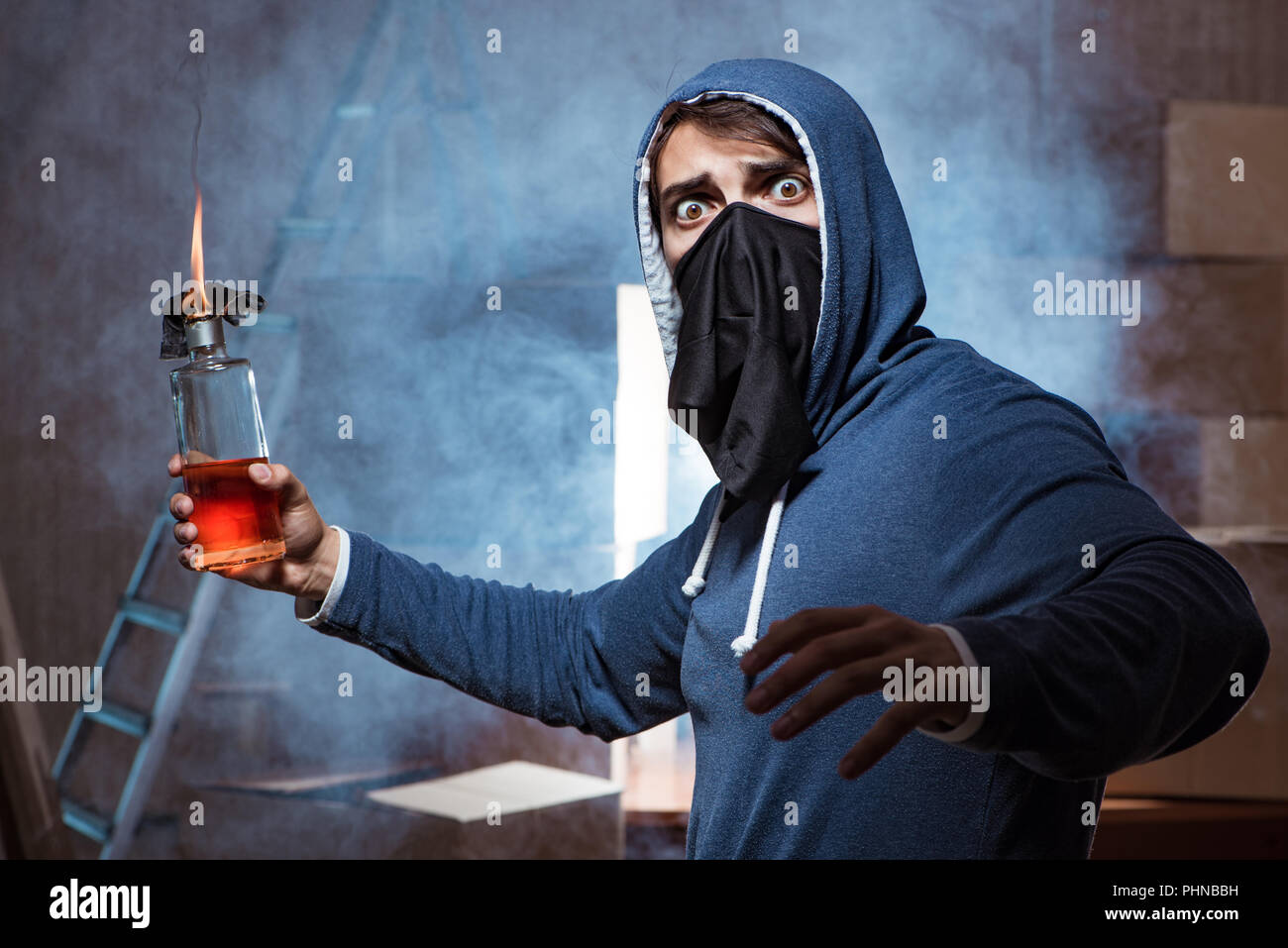 Rebel with molotov cocktail in dark room Stock Photo - Alamy