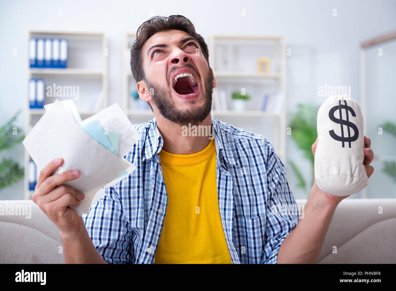Man angry at bills he needs to pay Stock Photo - Alamy
