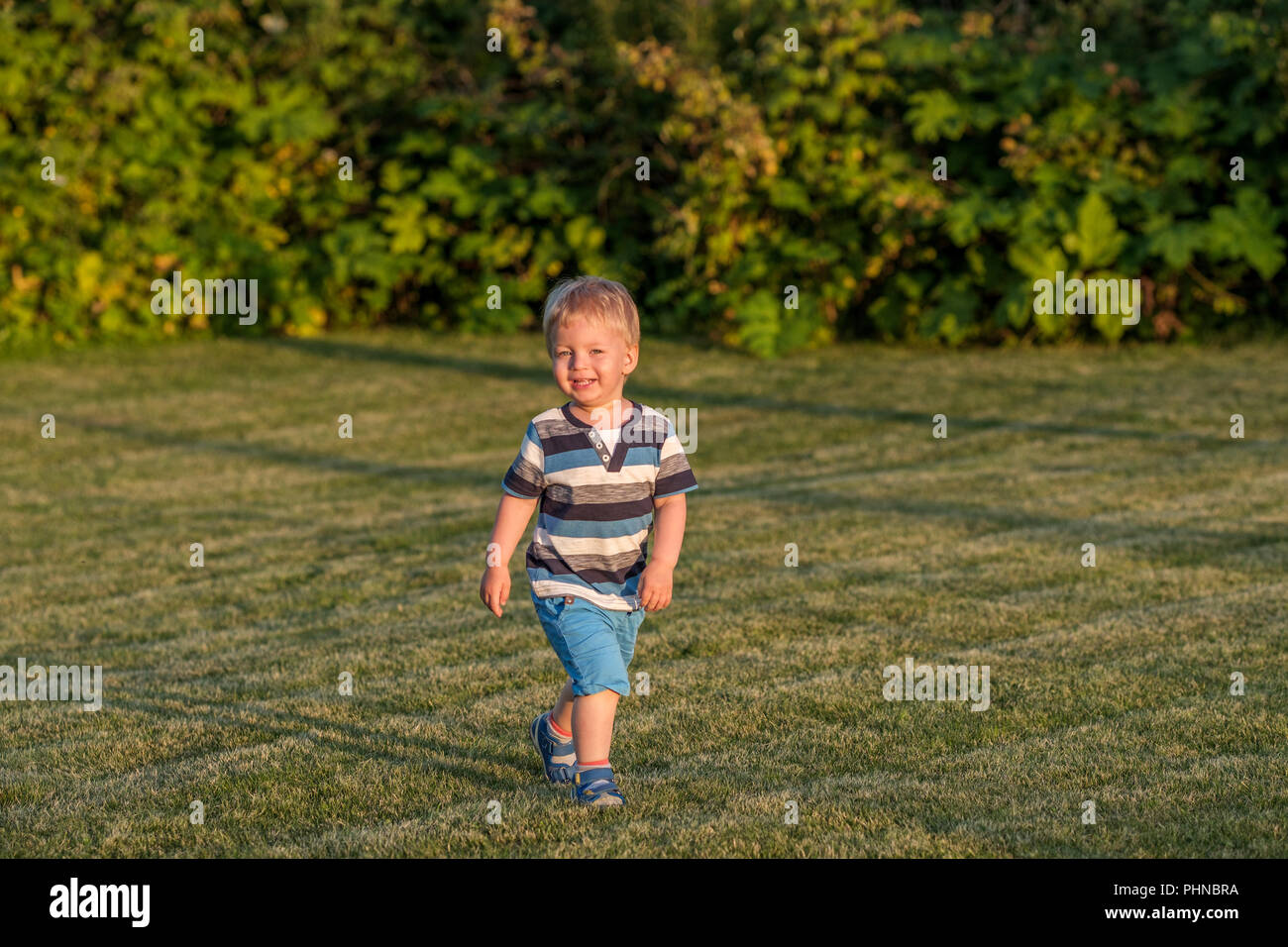 One year old baby boy running on meadow Stock Photo - Alamy