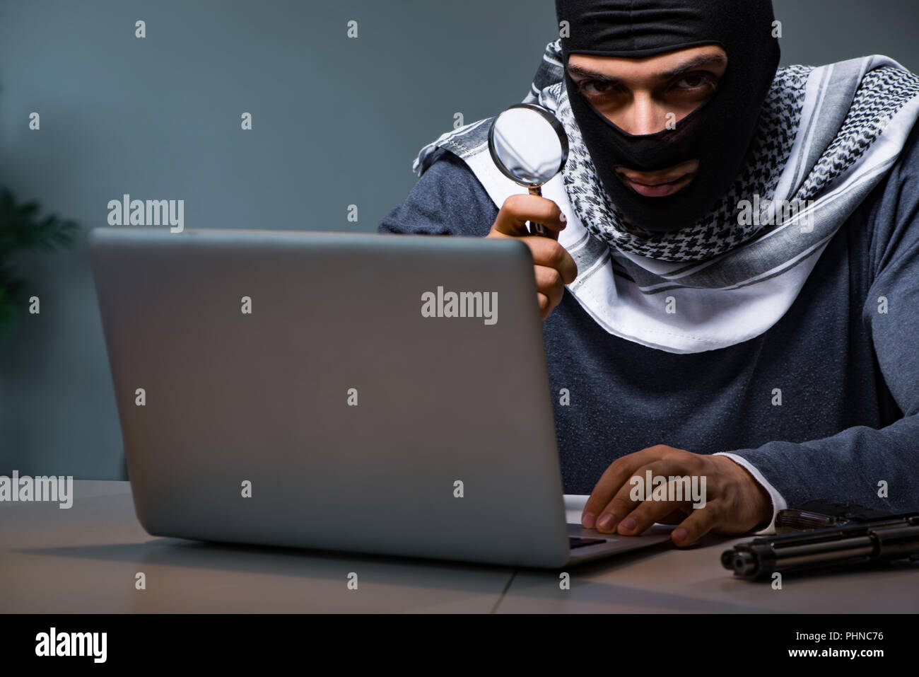 Hacker wearing balaclava mask hacking computer Stock Photo - Alamy