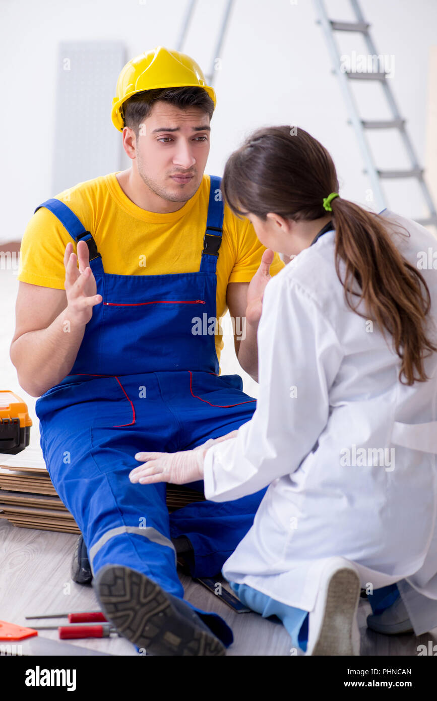 Doctor helping injured worker at construction site Stock Photo - Alamy