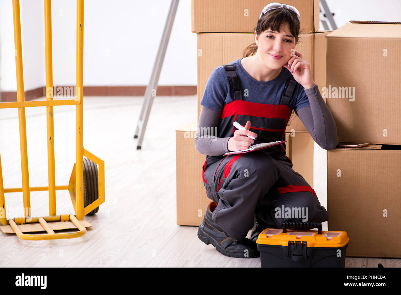 Woman contractor moving boxes in relocation concept Stock Photo - Alamy