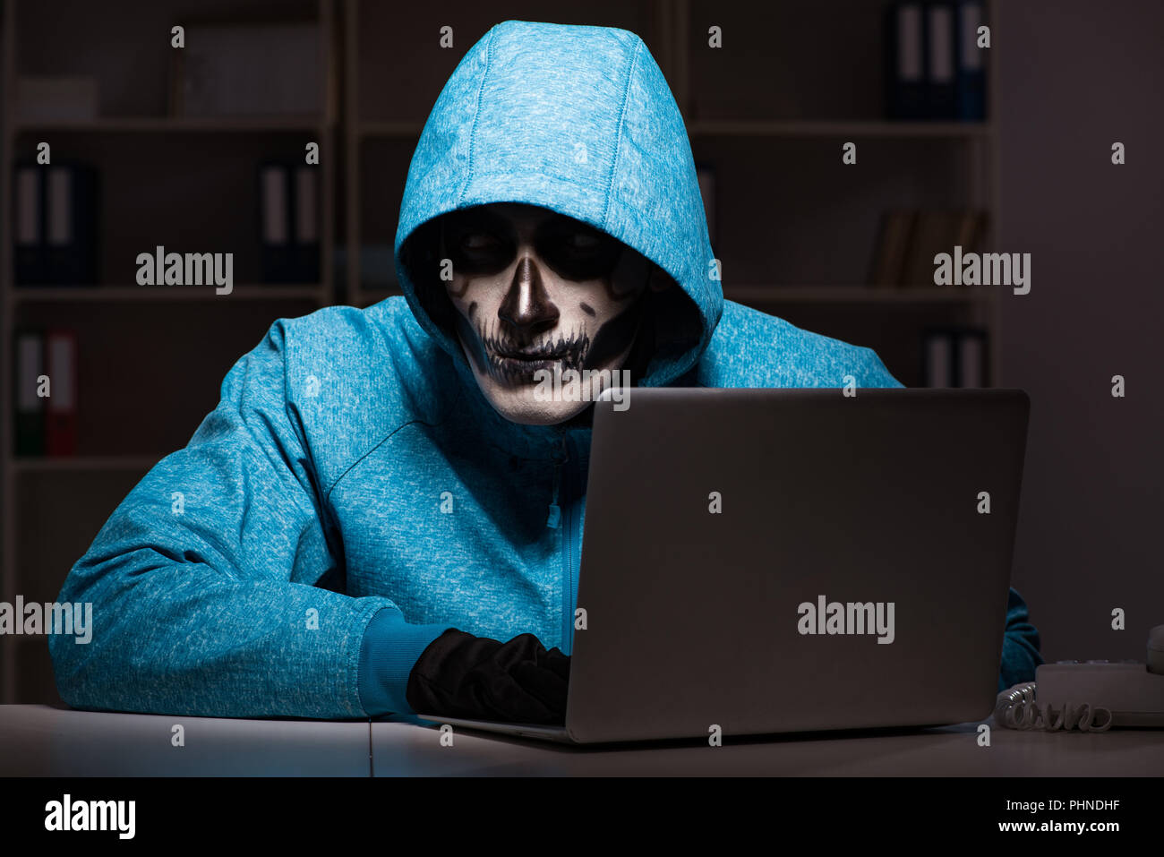Scary hacker hacking security firewall late in office Stock Photo - Alamy