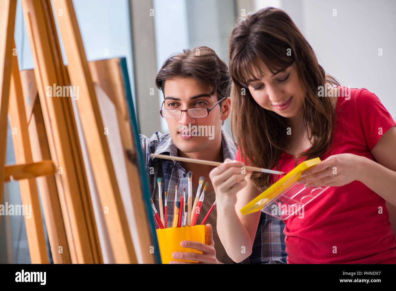 Artist coaching student in painting class in studio Stock Photo - Alamy