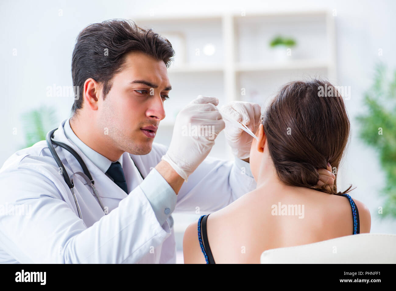 Doctor checking patients ear during medical examination Stock Photo - Alamy