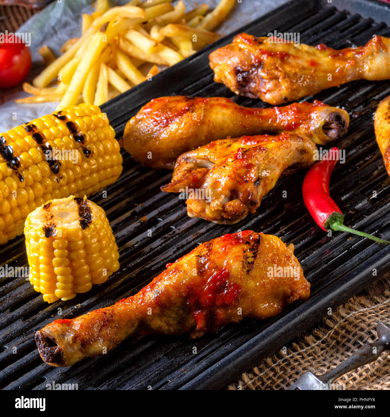 Rustic Grilled chicken wings,legs,and spicy corn Stock Photo - Alamy