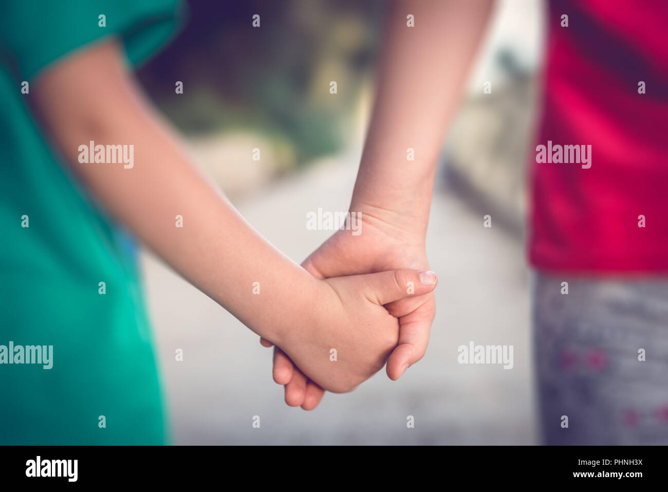 Siblings holding hands together Stock Photo - Alamy