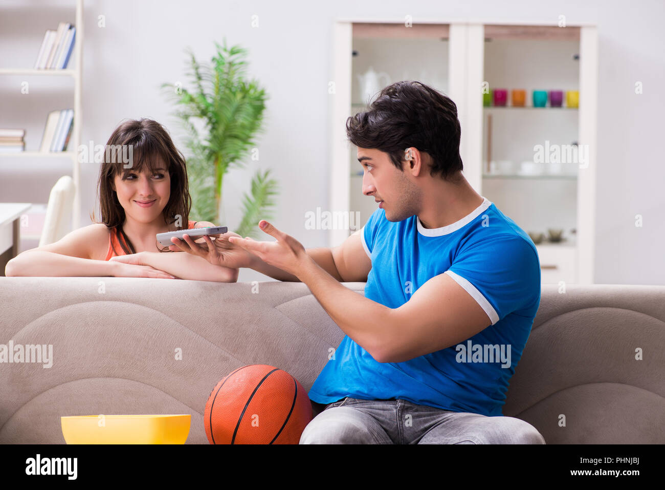 Man watching basketball with his wife Stock Photo - Alamy