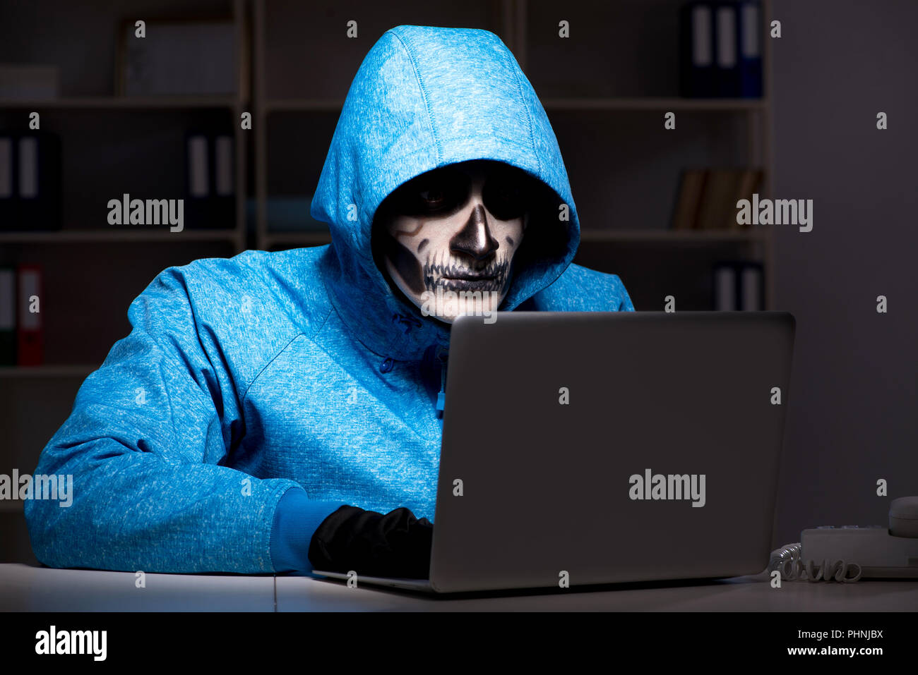 Scary hacker hacking security firewall late in office Stock Photo - Alamy