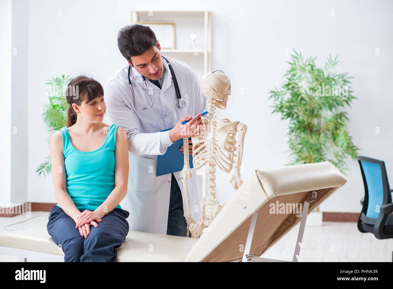 Doctor showing type of injury on skeleton to patient Stock Photo - Alamy
