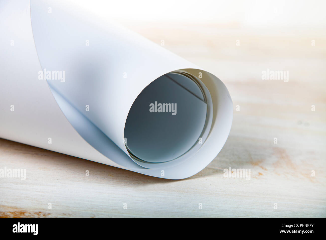 Roll of white paper on a wooden background Stock Photo - Alamy