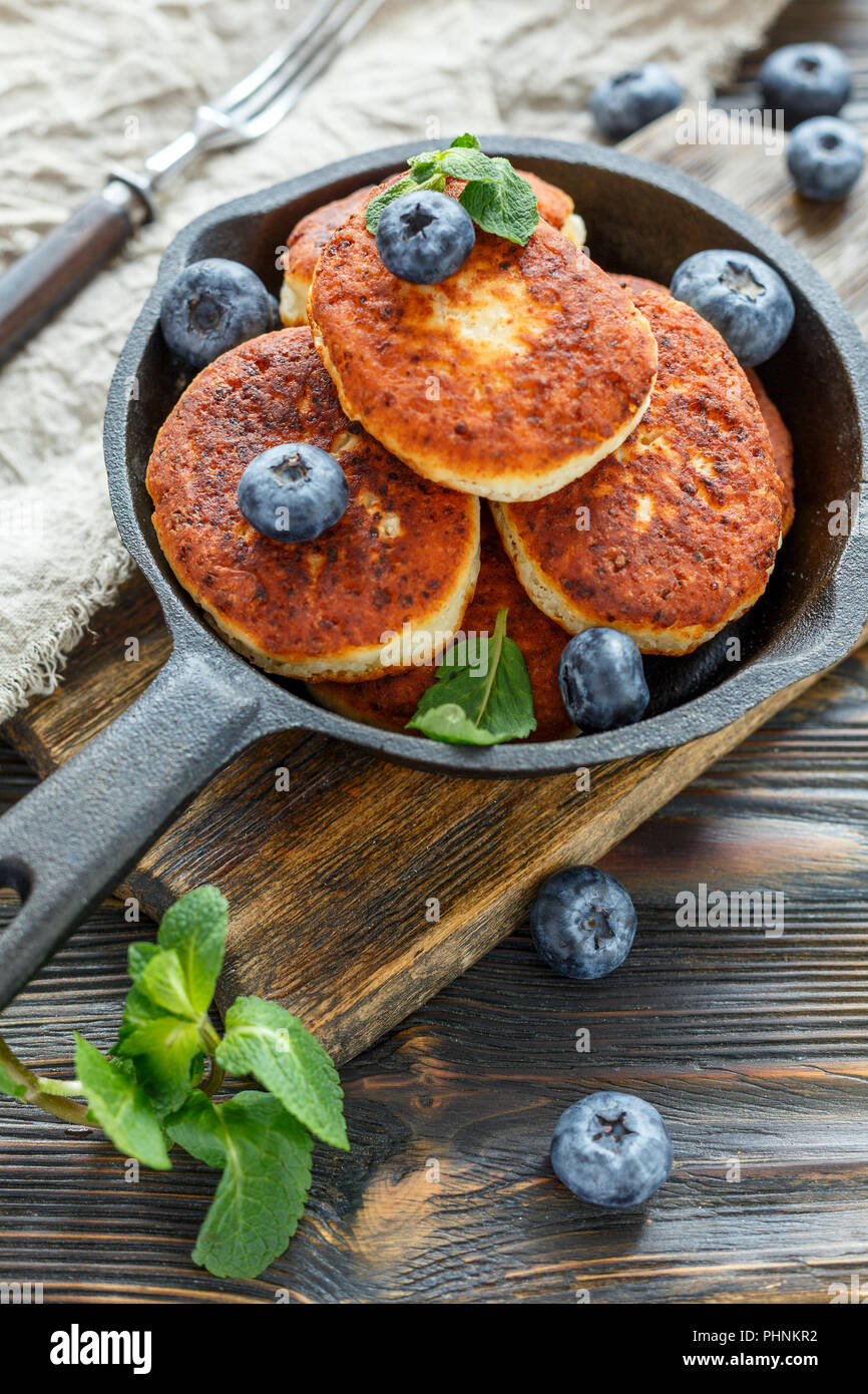 Cheese pancakes and blueberries in cast iron pan Stock Photo - Alamy