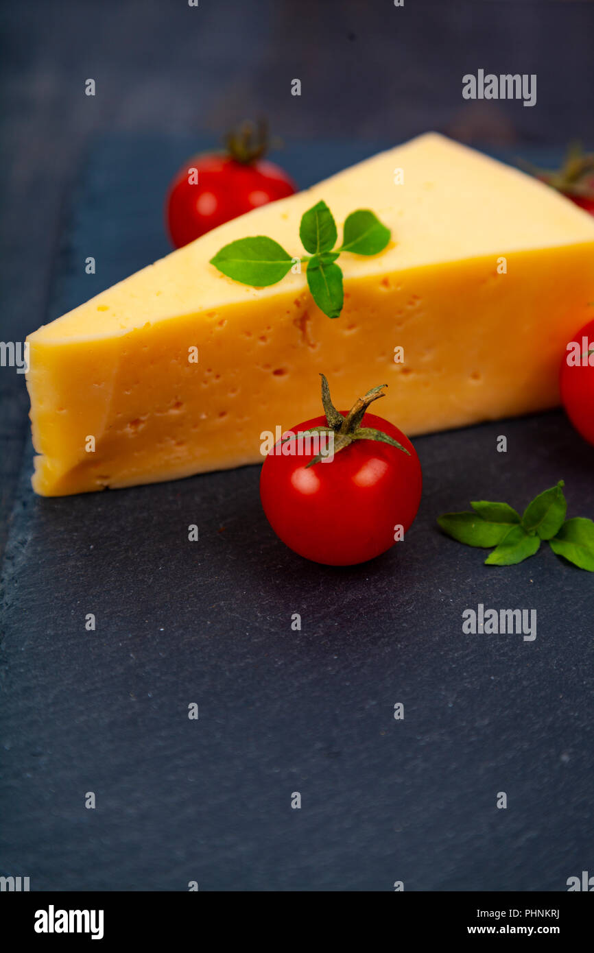Cheese, cherry tomatoes and basil on a dark background Stock Photo - Alamy