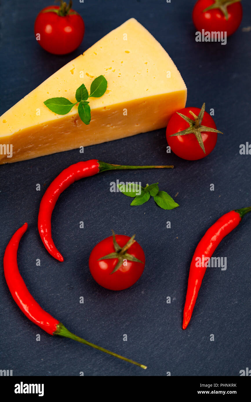 Cheese, cherry tomatoes and basil on a dark background Stock Photo - Alamy