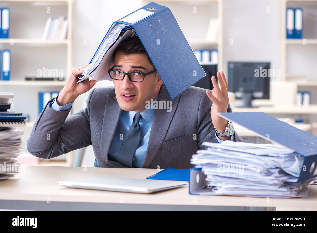 Overloaded with work employee under paperwork burden Stock Photo - Alamy