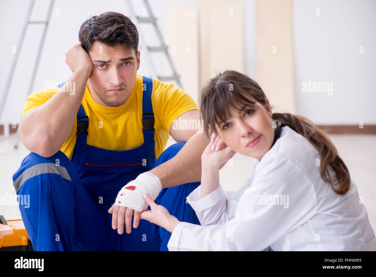 Injured worker being assisted by doctor Stock Photo - Alamy