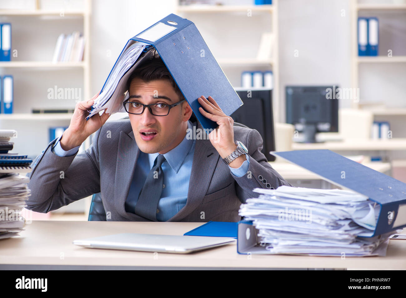 Overloaded with work employee under paperwork burden Stock Photo - Alamy
